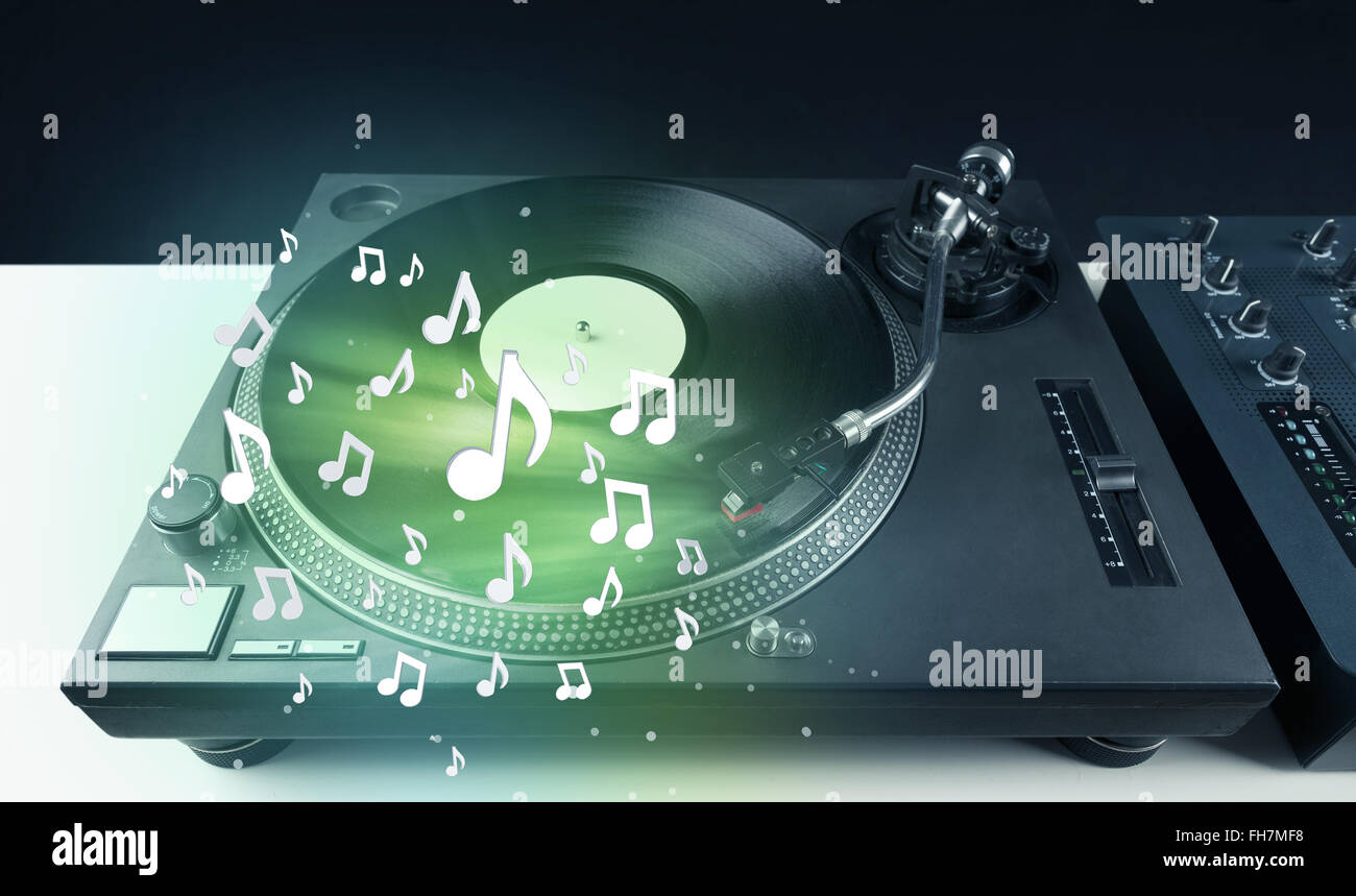 Turntable playing music with audio notes glowing Stock Photo - Alamy