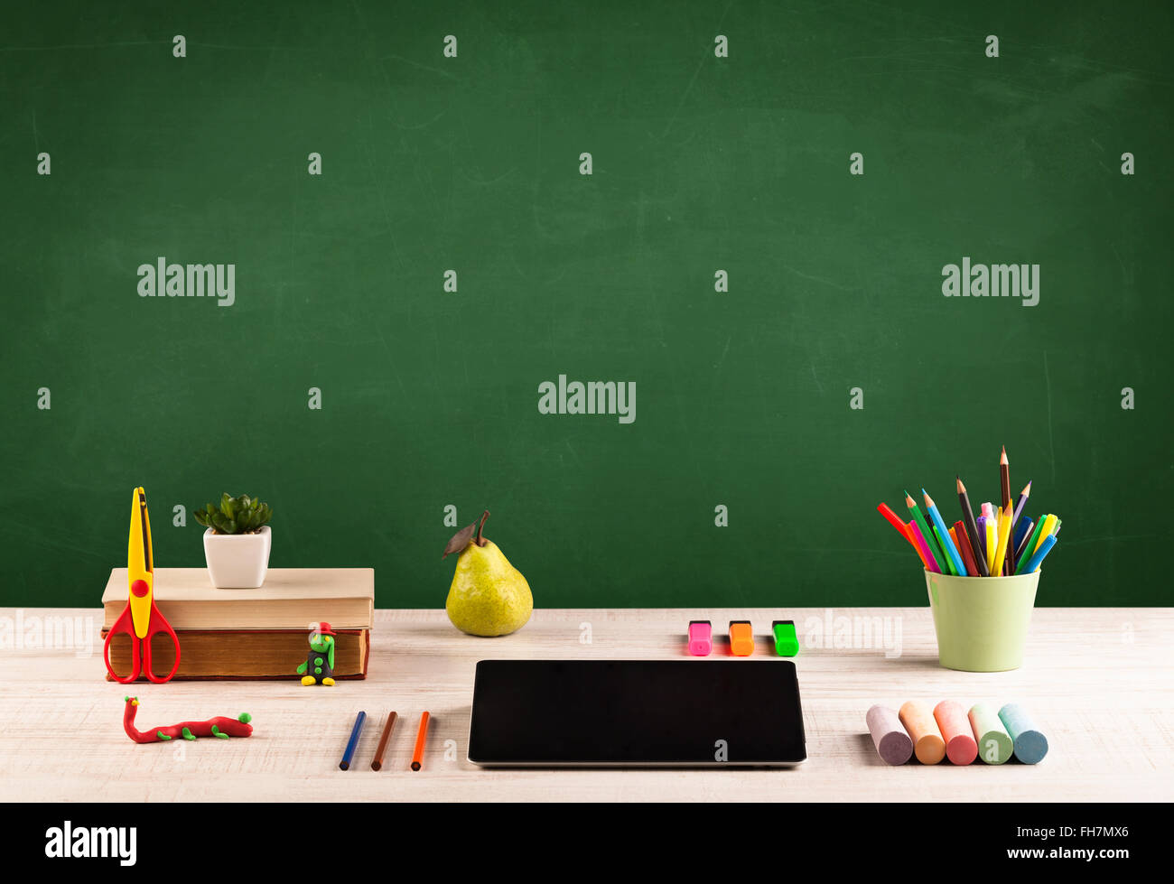 School items on desk with empty chalkboard Stock Photo - Alamy