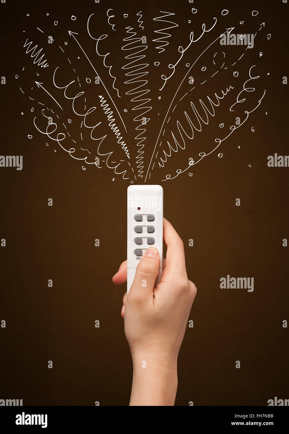 Hand with remote control and curly lines Stock Photo - Alamy