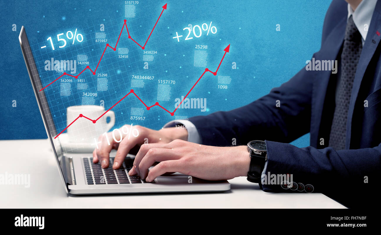 Salesman working on graph with laptop Stock Photo - Alamy