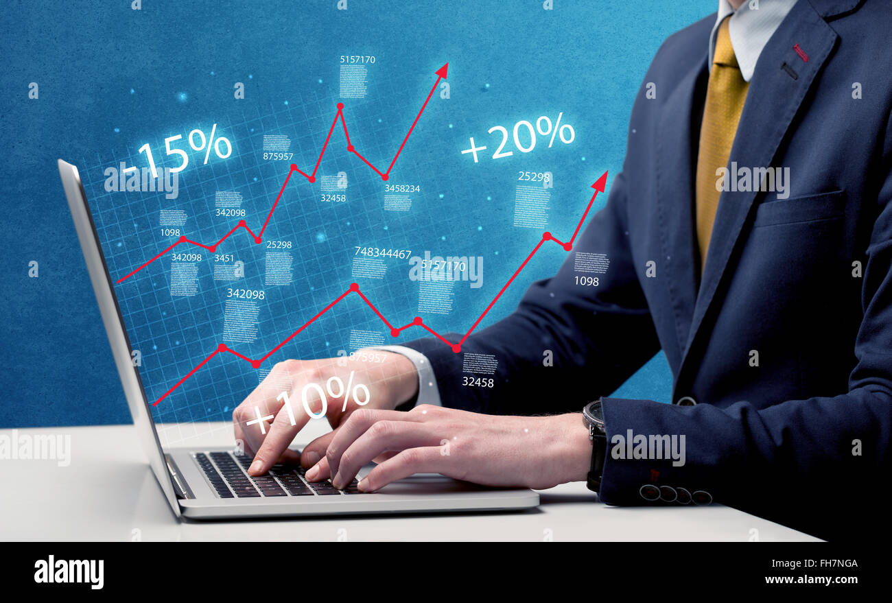 Salesman working on graph with laptop Stock Photo - Alamy