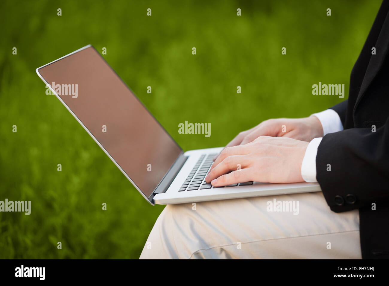 Businessman pressing modern laptop computer on colorful background ...