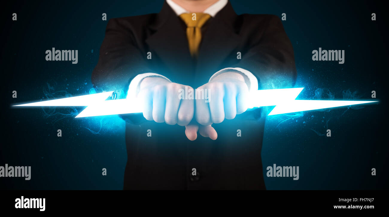 Business man holding glowing lightning bolt in his hands Stock Photo ...