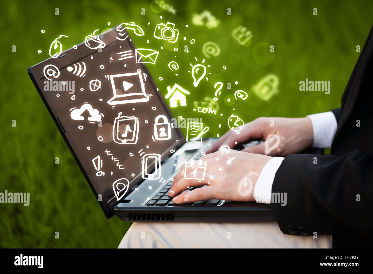 Hand writing on notebook computer with media icons and symbols Stock ...