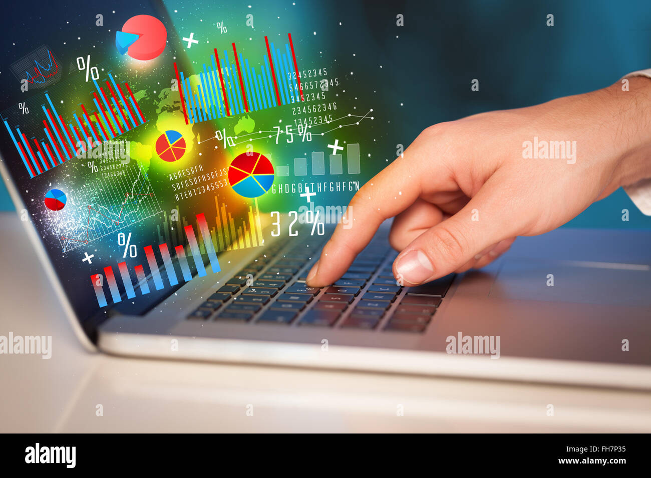 Hand typing on modern laptop notebook computer with graph icons and ...