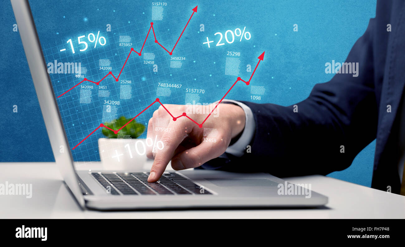 Salesman working on graph with laptop Stock Photo - Alamy