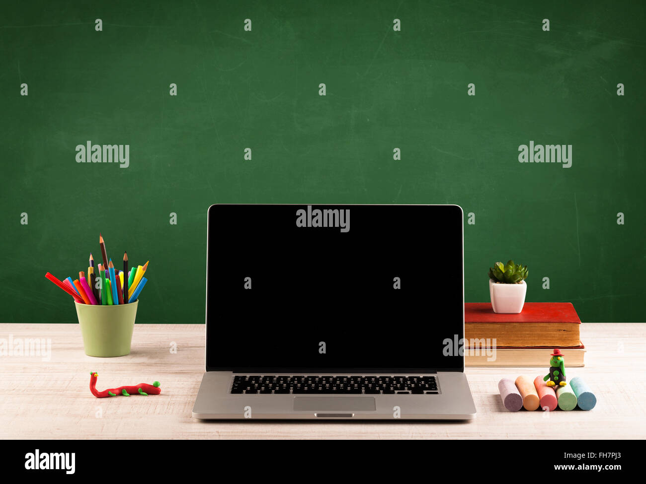 School items on desk with empty chalkboard Stock Photo - Alamy
