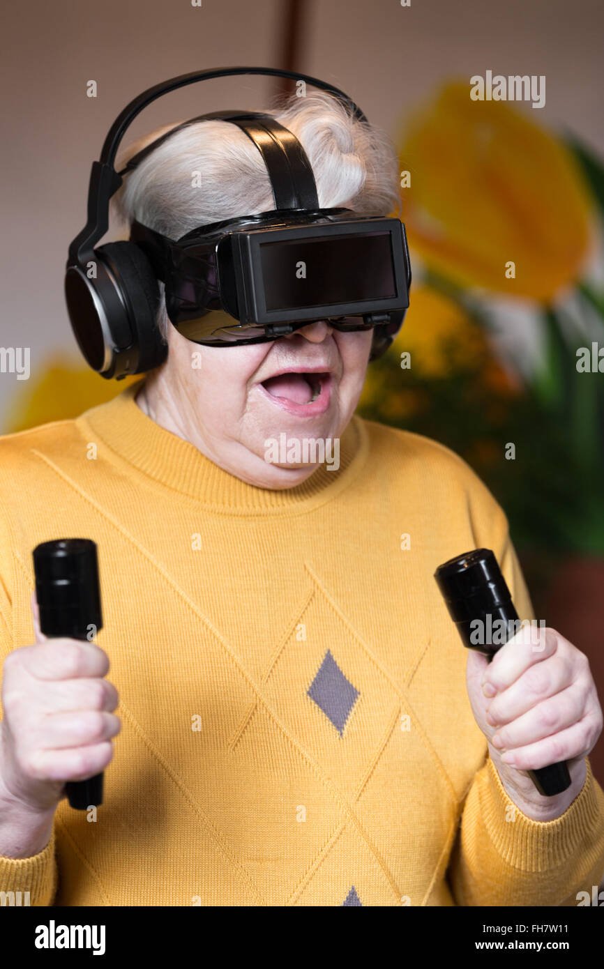 elderly woman with gaming simulator and controller is looking surprised ...