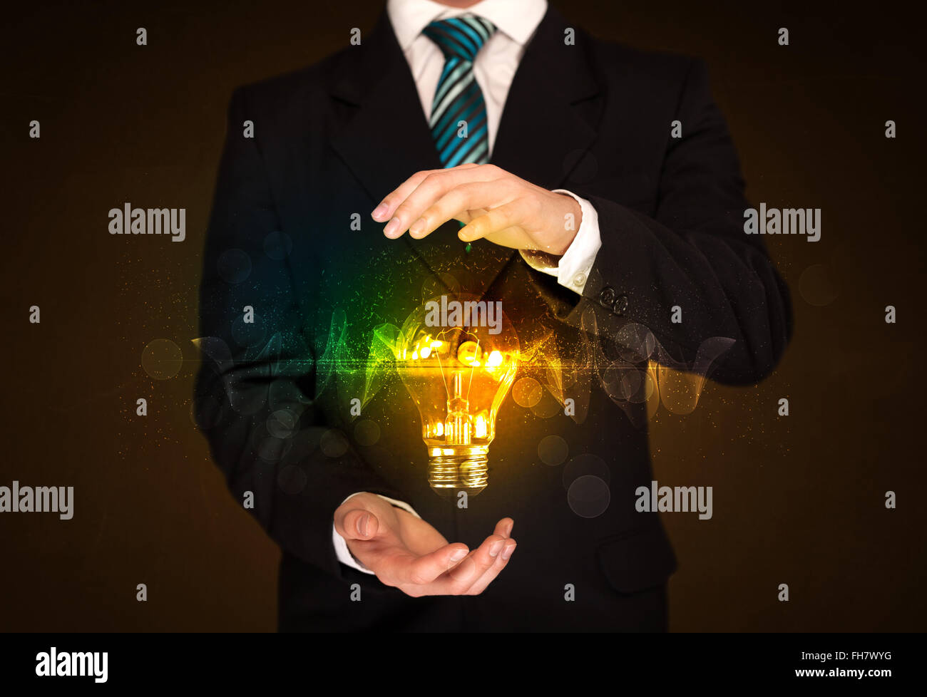 Businessman holding light bulb Stock Photo - Alamy
