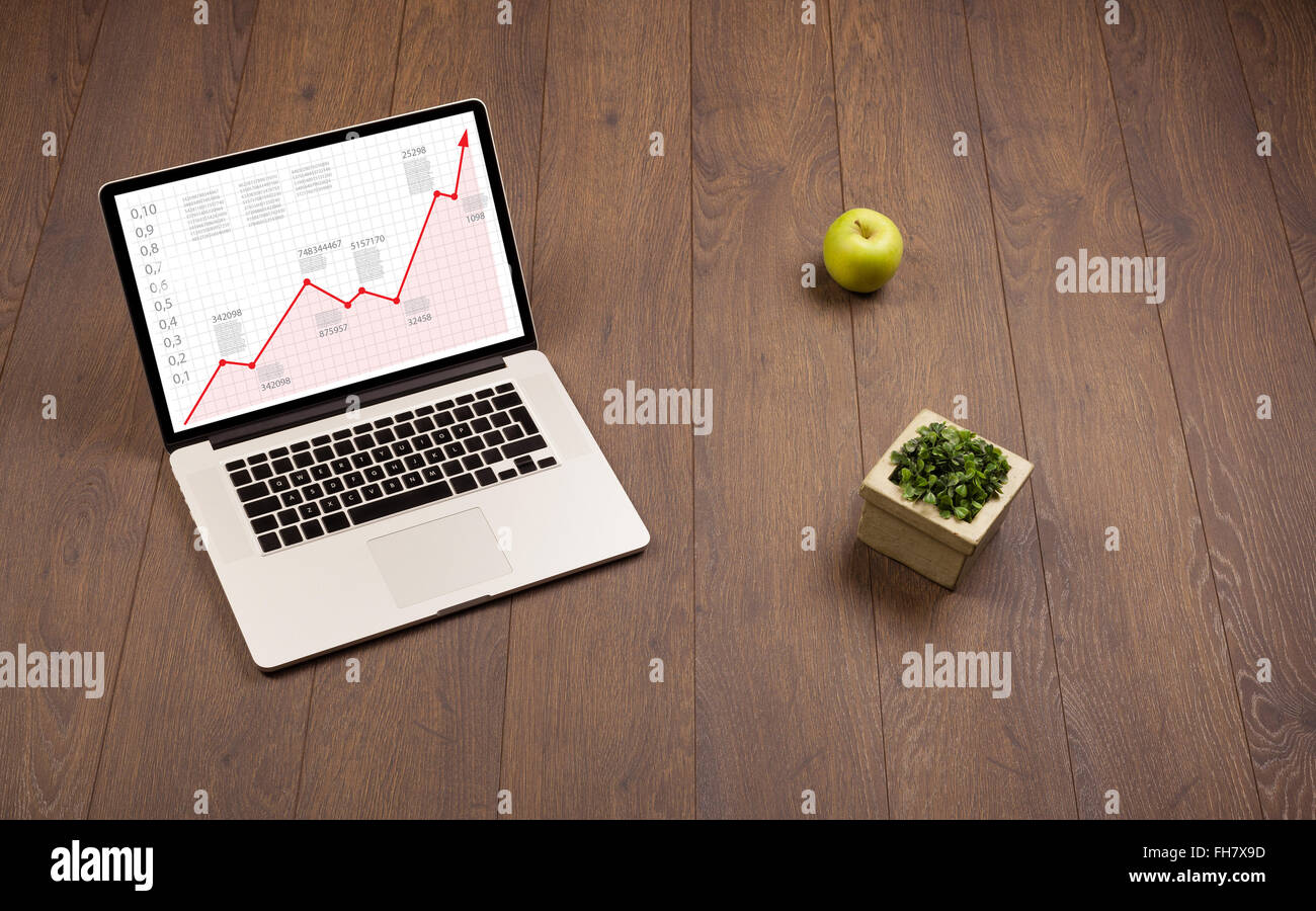 Computer desk with laptop and red arrow chart in screen Stock Photo - Alamy