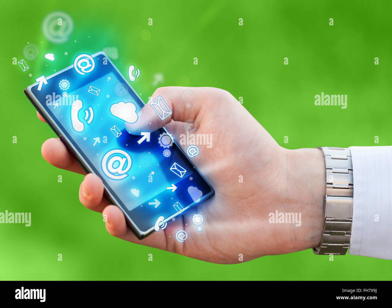Business man holding smart phone with media icons Stock Photo - Alamy