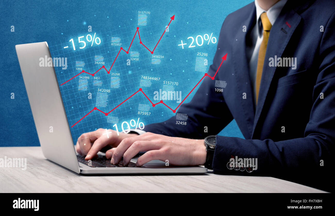 Salesman working on graph with laptop Stock Photo - Alamy
