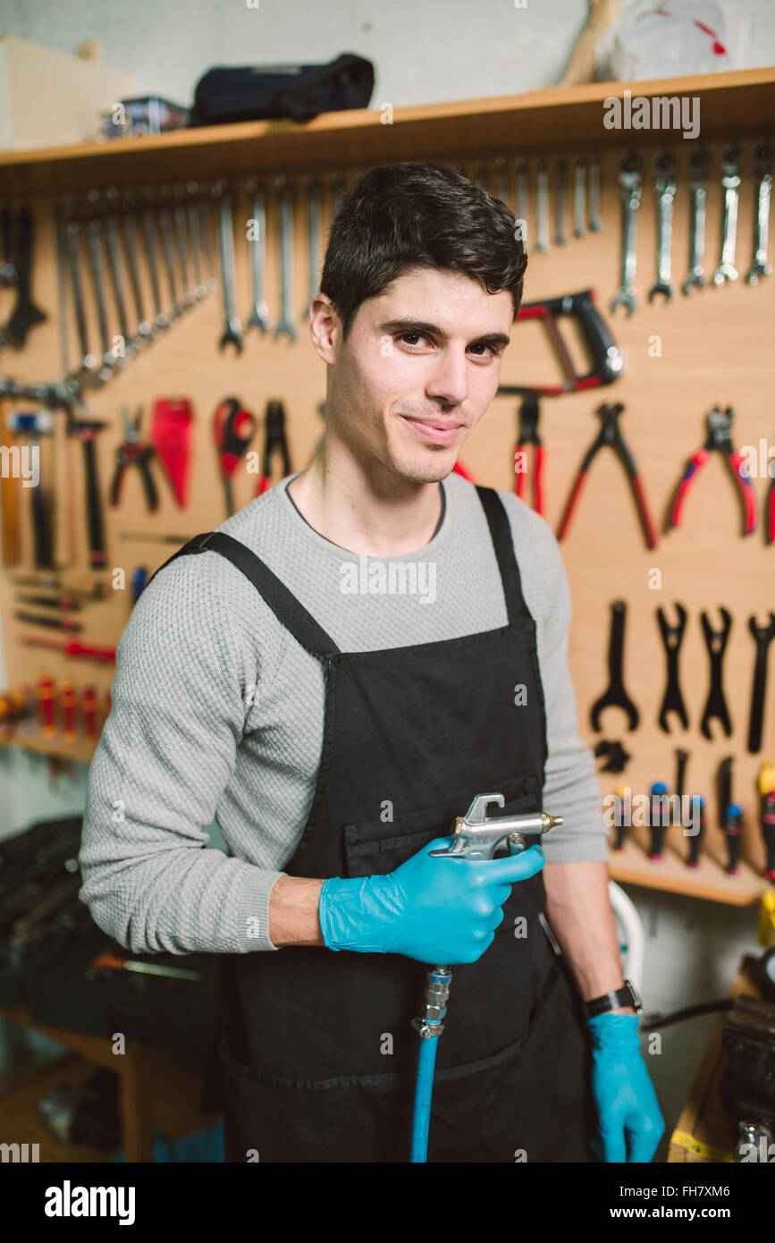 Portrait of a mechanic in his workshop holding a compressor gun Stock ...