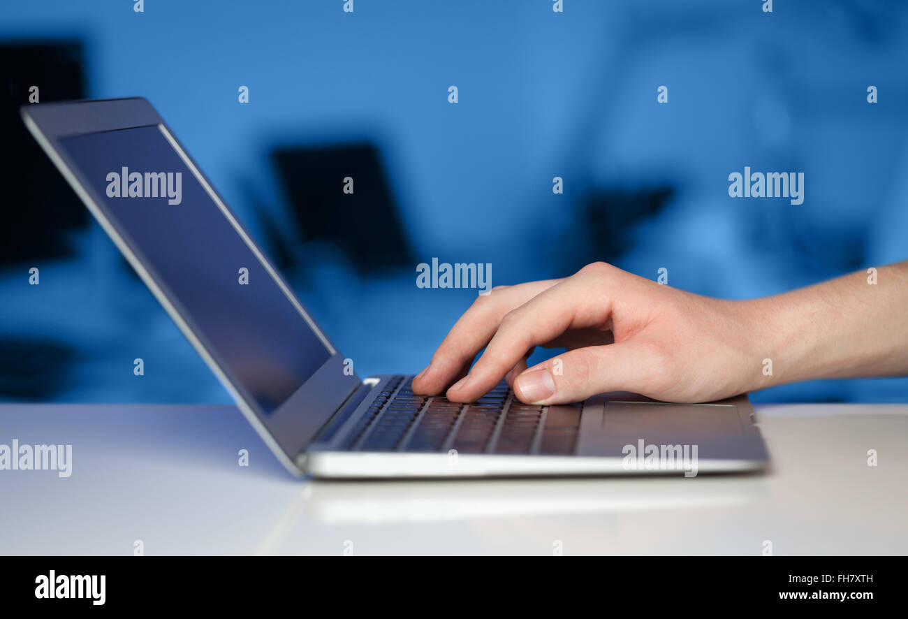 Businessman pressing modern laptop computer on colorful background ...