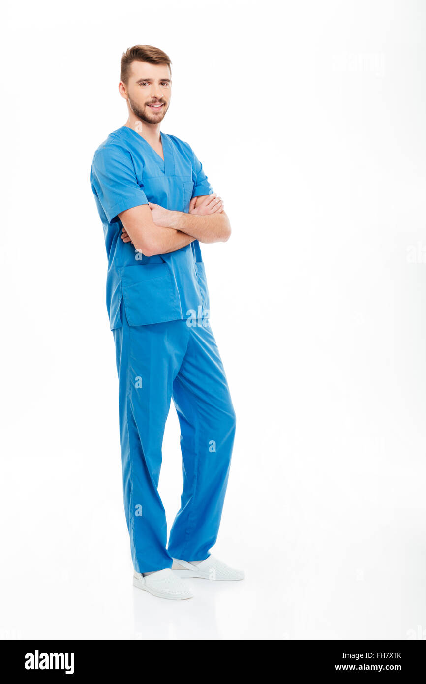 Full length portrait of a happy male doctor standing with arms folded ...