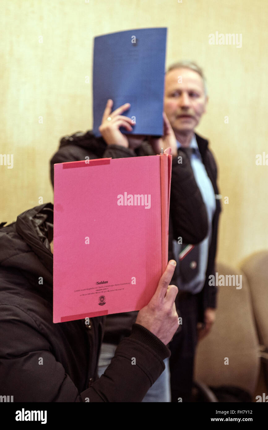 Two defendants hold file folders in front their faces in the courtroom ... Two defendants hold file folders in front their faces in the courtroom ...