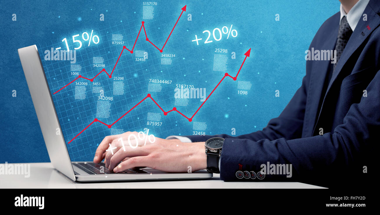 Salesman working on graph with laptop Stock Photo - Alamy