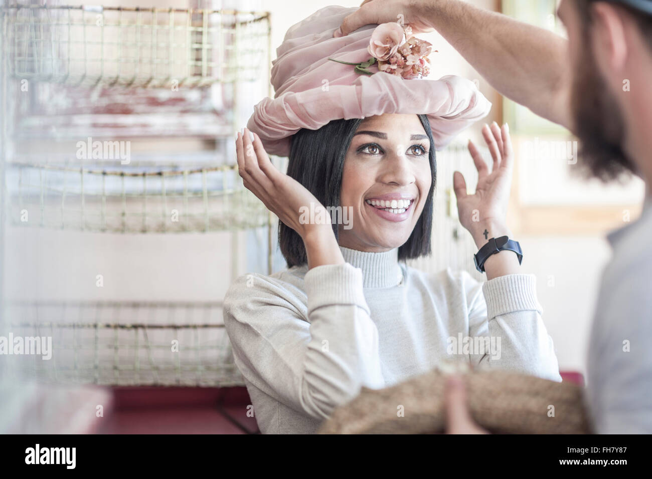 Portrait of woman putting on an old hat in antique shop Stock Photo - Alamy