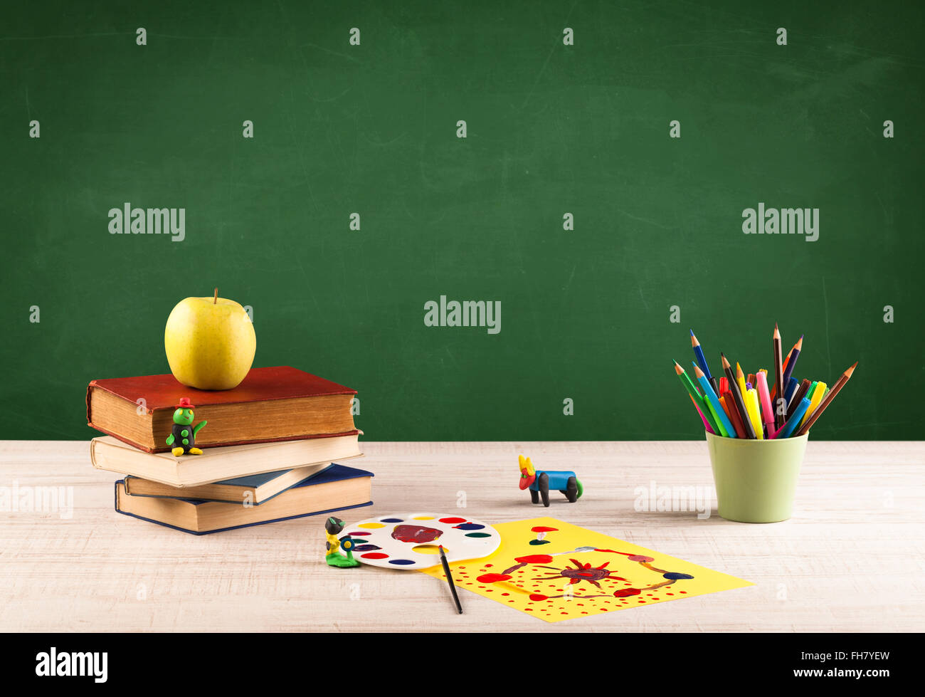 School items on desk with empty chalkboard Stock Photo - Alamy