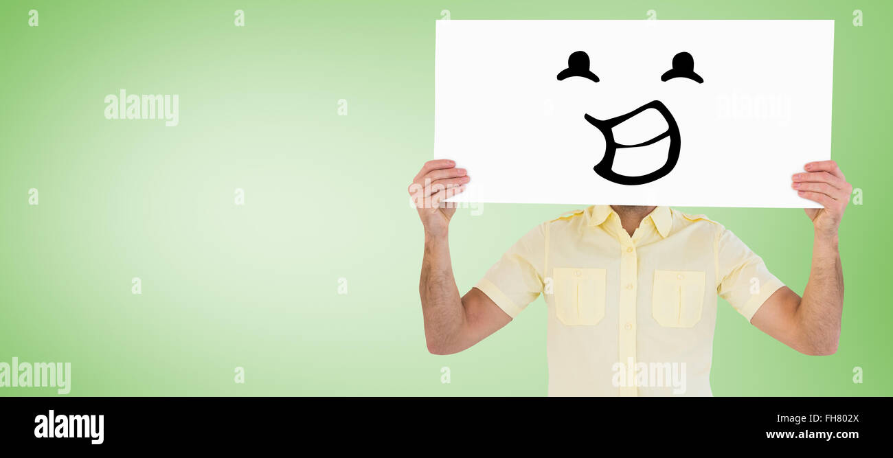 Composite image of man holding card in front of his face Stock Photo ...