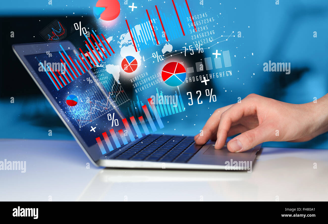 Hand typing on modern laptop notebook computer with graph icons and ...