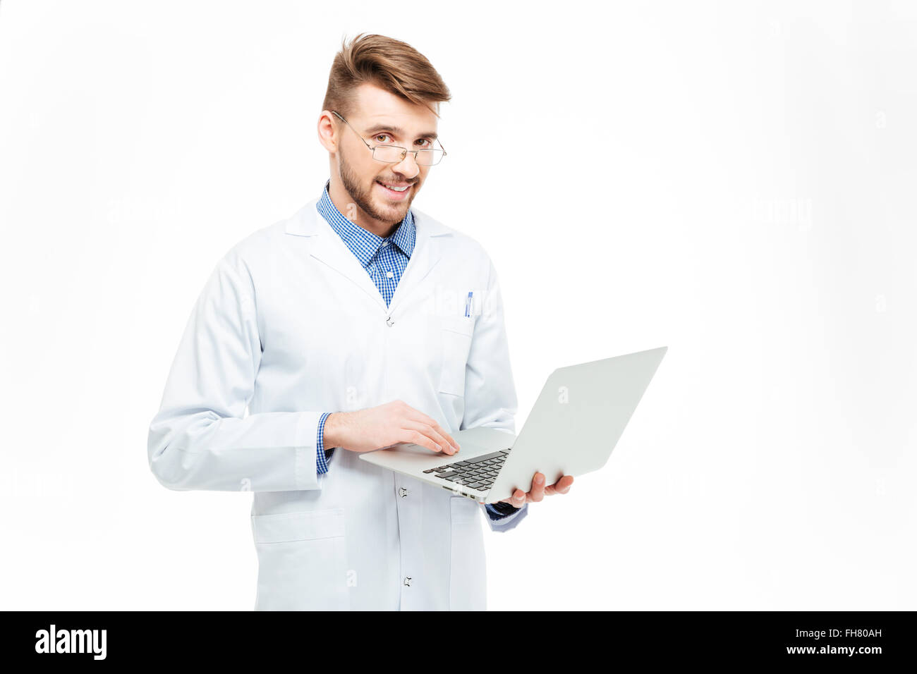 Happy male doctor using laptop computer isolated on a white background ...