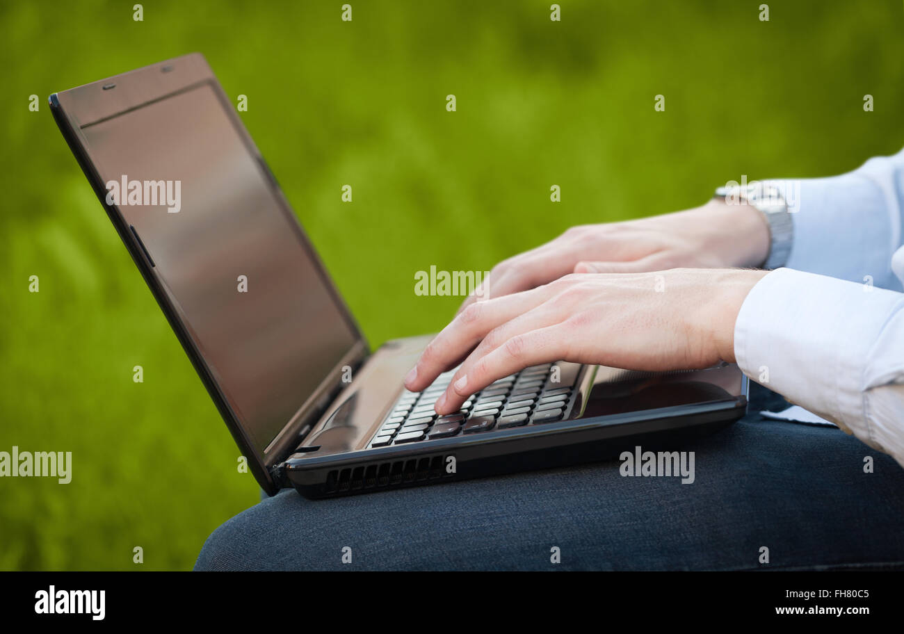 Businessman pressing modern laptop computer on colorful background ...