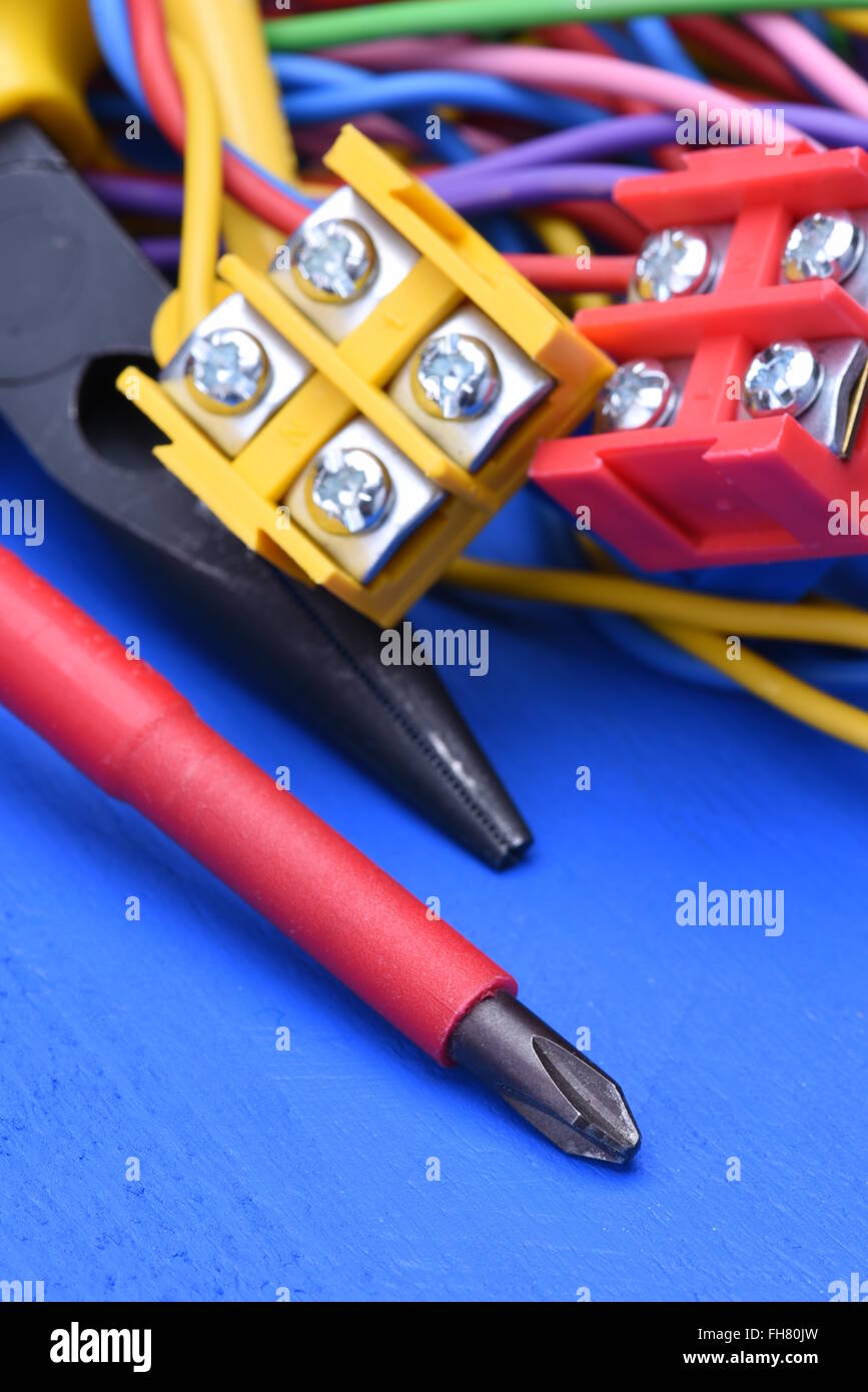 Tools and component kit used in electrical installations on blue wooden ...