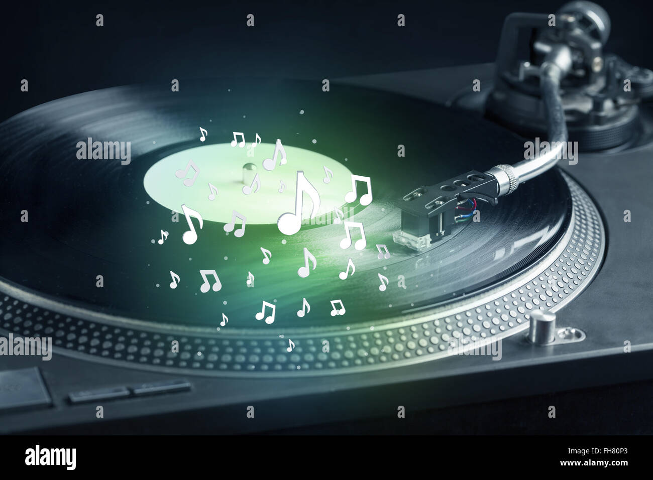 Turntable playing music with audio notes glowing Stock Photo - Alamy