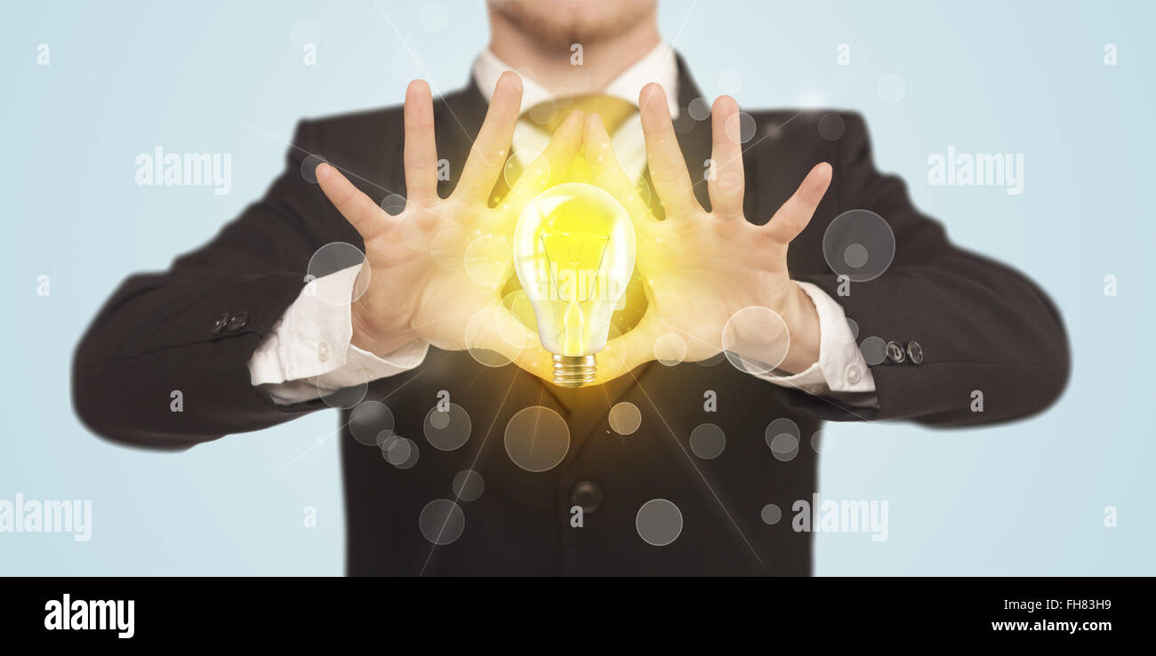 Hands creating a form with light bulb Stock Photo - Alamy