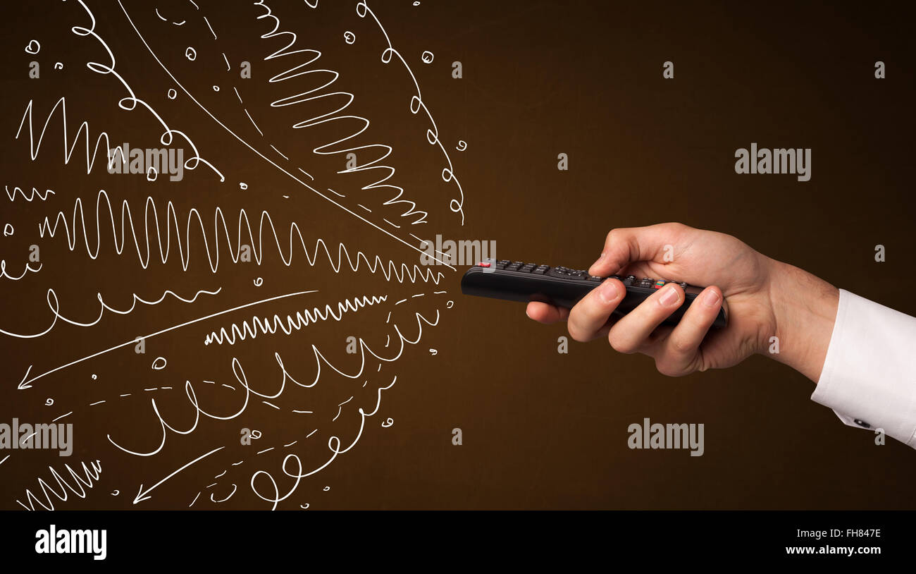 Hand with remote control and curly lines Stock Photo - Alamy