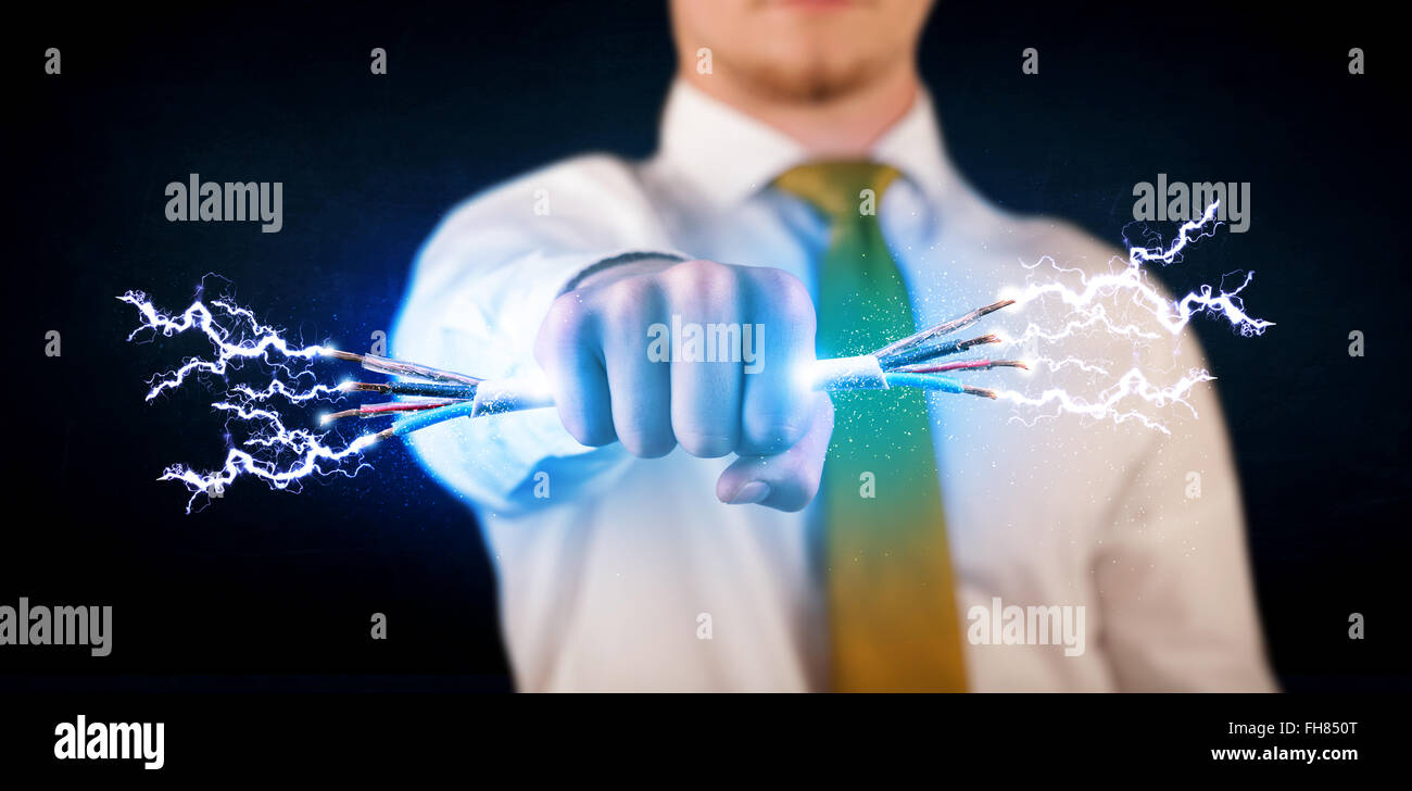 Business person holding electrical powered wires Stock Photo - Alamy