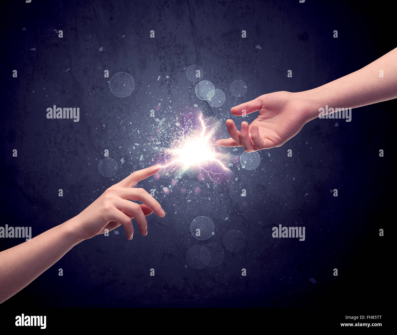 Hands reaching to light a spark Stock Photo - Alamy
