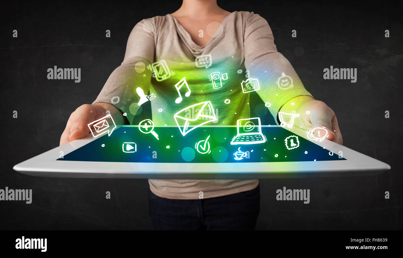 Person holding a tablet with media icons and symbols Stock Photo - Alamy