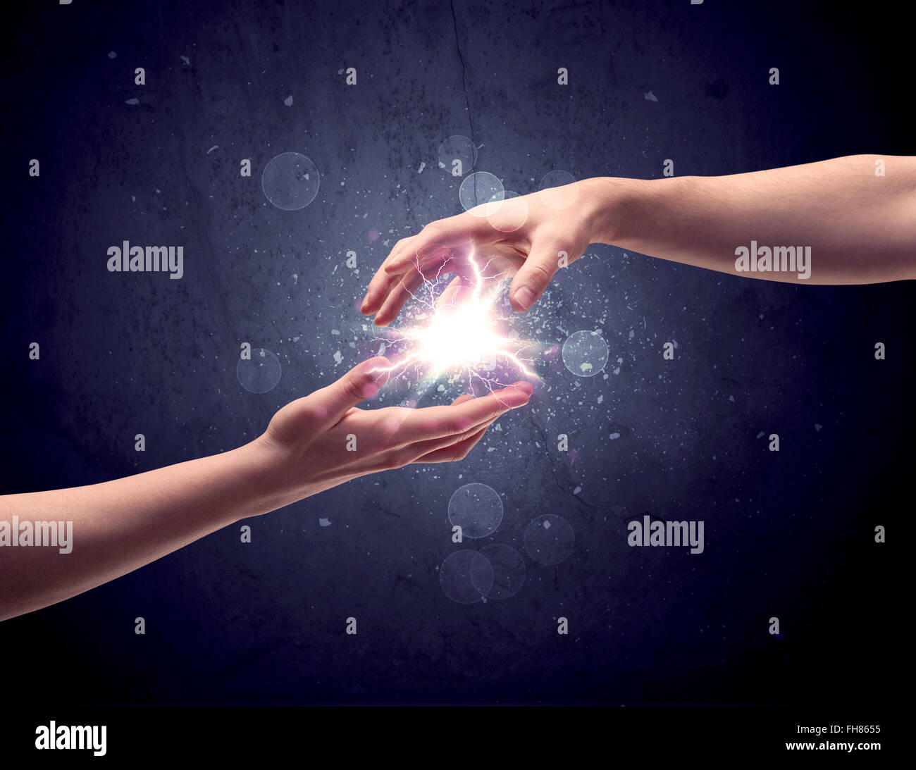Hands reaching to light a spark Stock Photo - Alamy