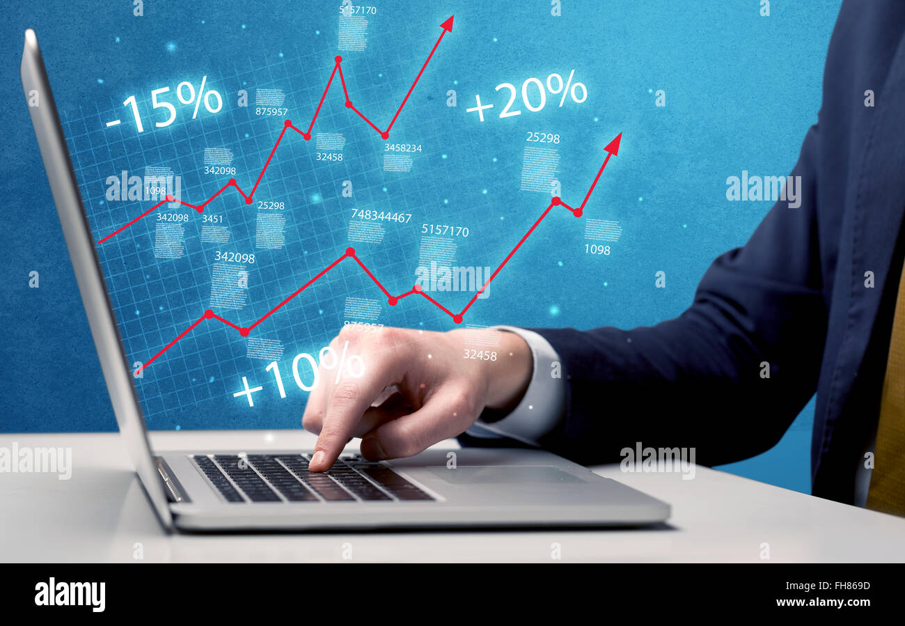 Salesman working on graph with laptop Stock Photo - Alamy