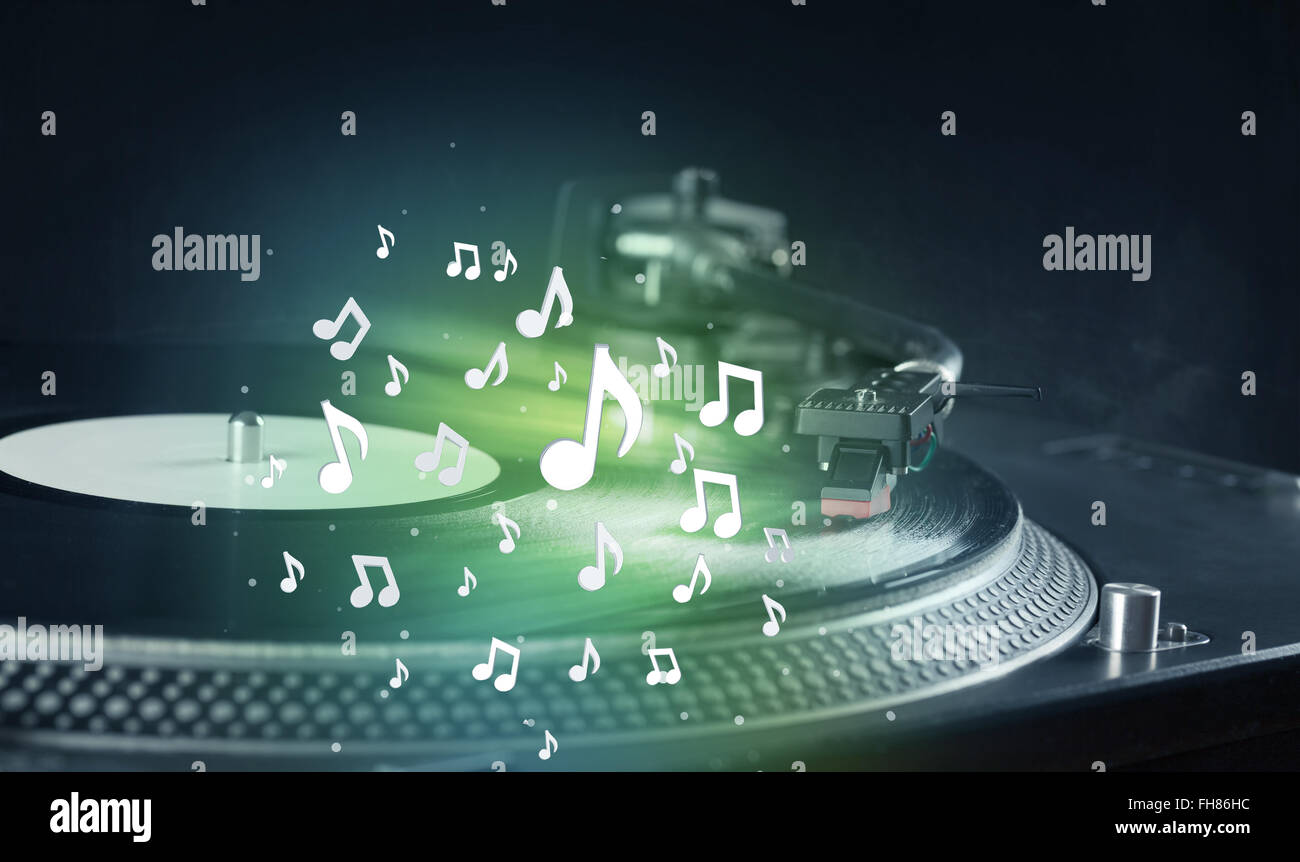 Turntable playing music with audio notes glowing Stock Photo - Alamy