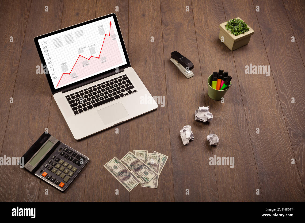 Computer desk with laptop and red arrow chart in screen Stock Photo - Alamy