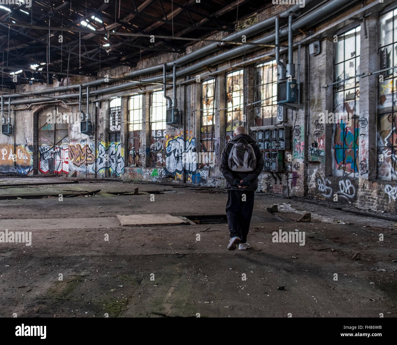 Senior man exploring interior of derelict railway turntable shed at ...