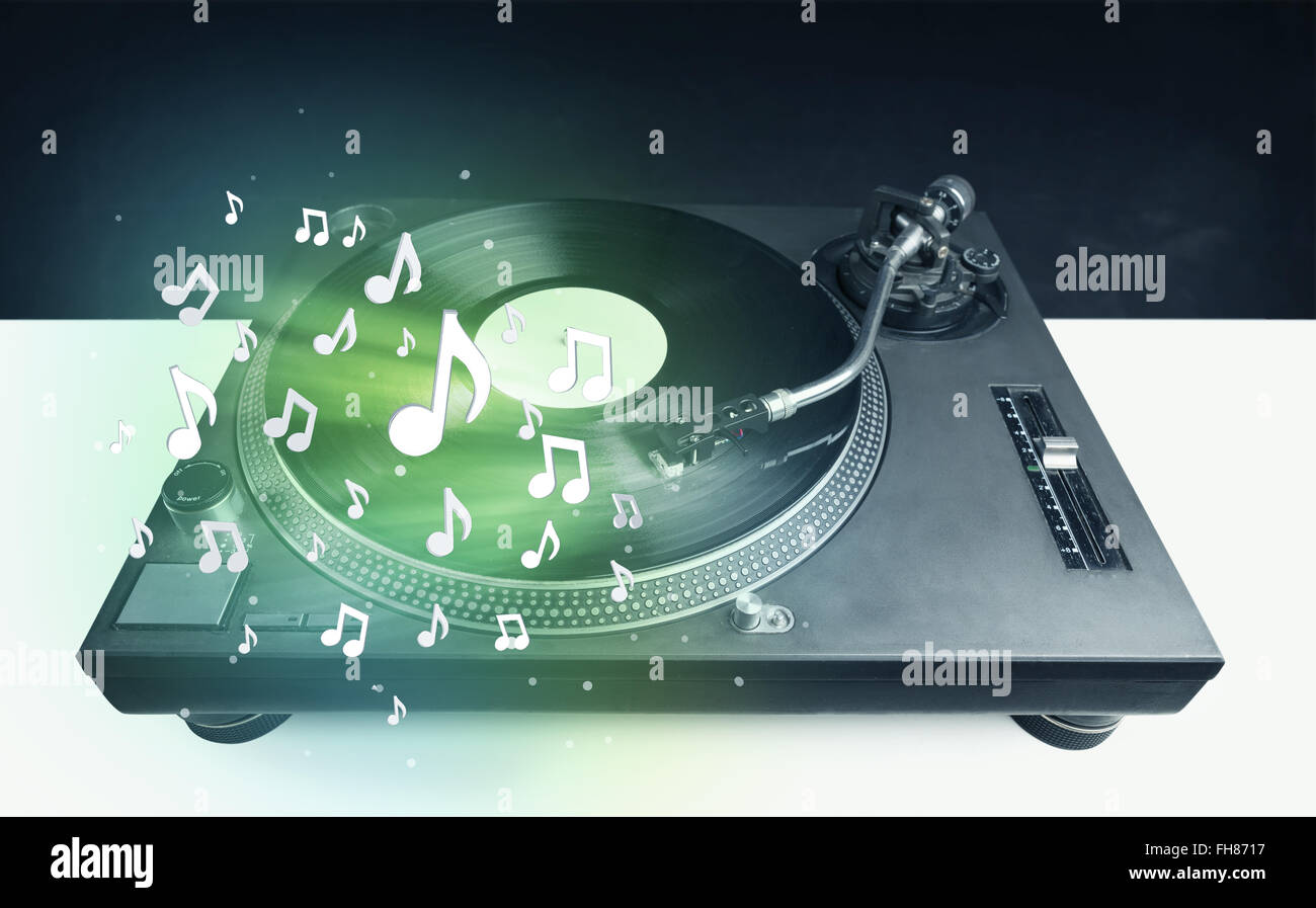 Turntable playing music with audio notes glowing Stock Photo - Alamy