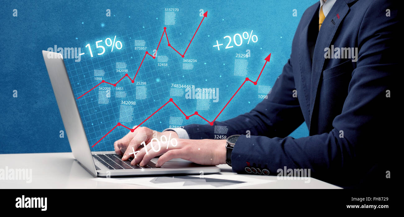 Salesman working on graph with laptop Stock Photo - Alamy