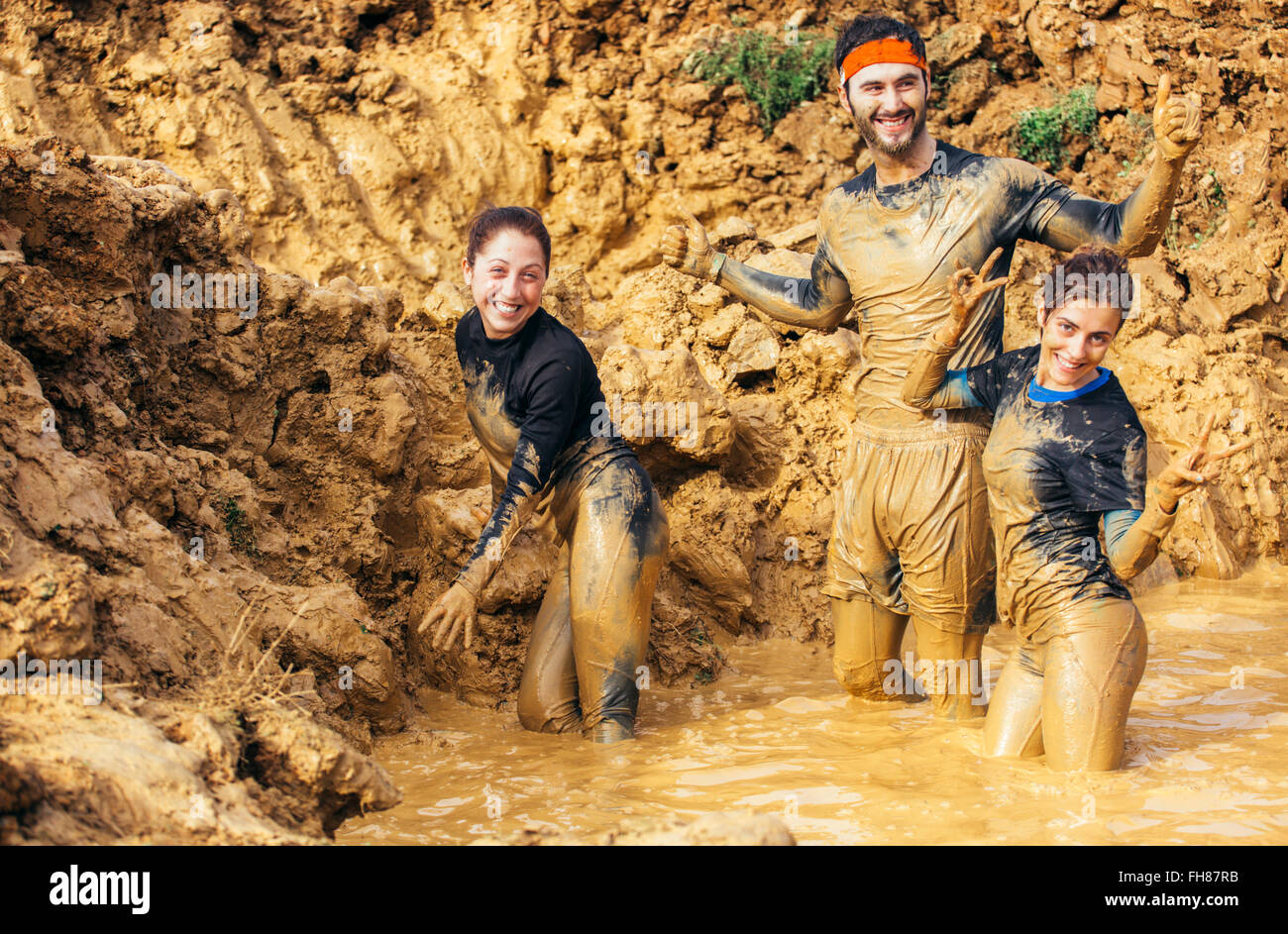Participants in extreme obstacle race, running through mud Stock Photo ...