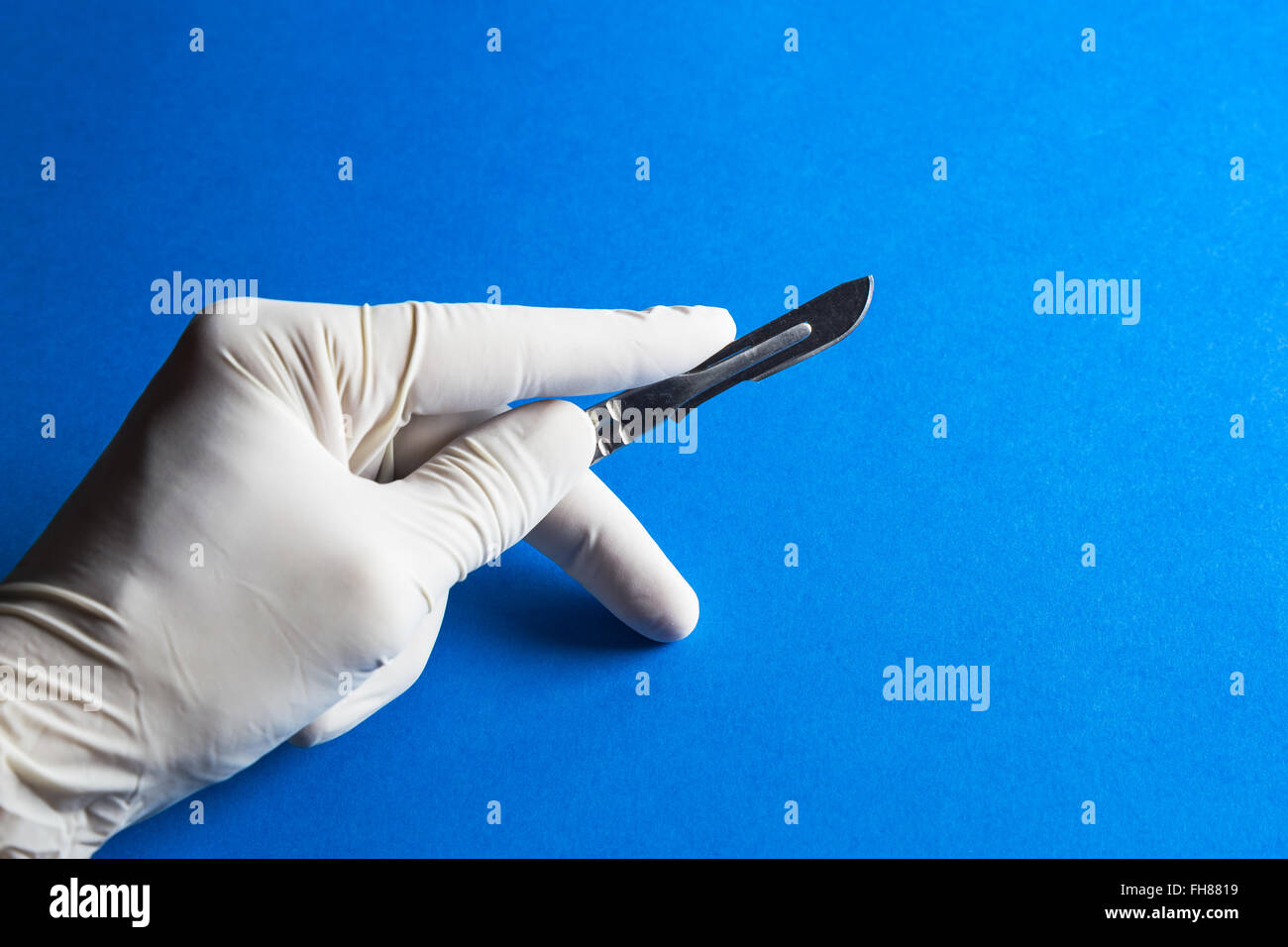 Medical scalpel in a hand with rubber glove Stock Photo - Alamy