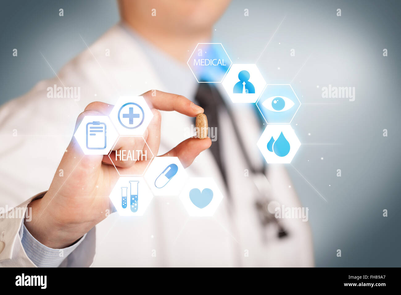 A doctor in white holding a pill Stock Photo - Alamy