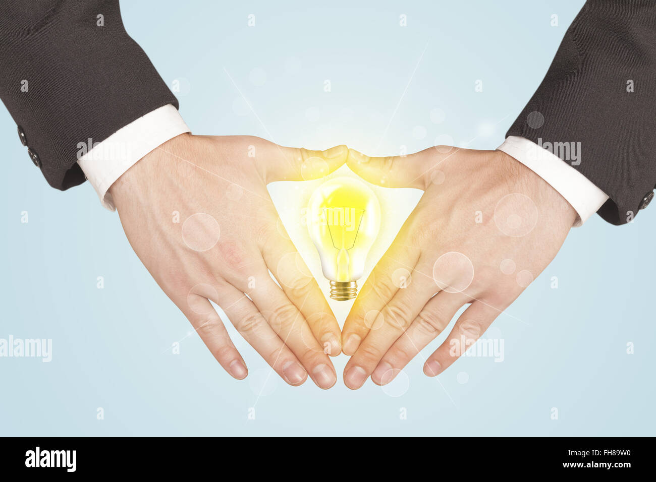 Hands creating a form with light bulb Stock Photo - Alamy