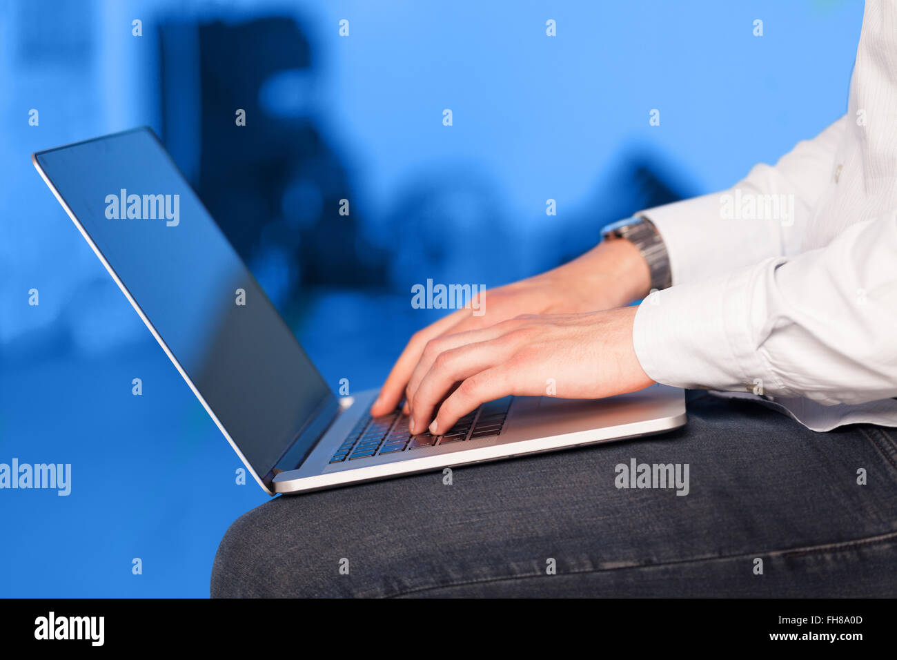 Businessman pressing modern laptop computer on colorful background ...