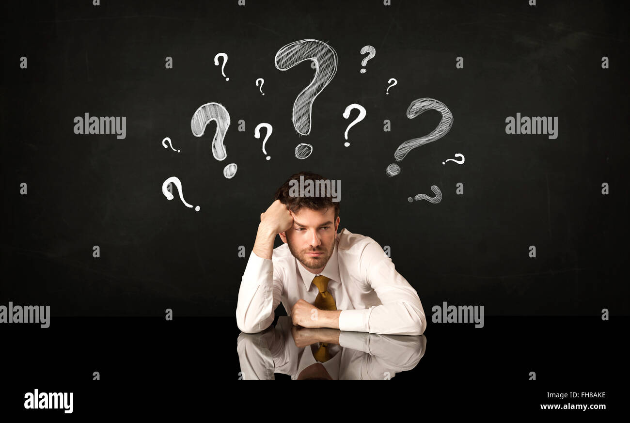 Sitting businessman under question marks Stock Photo - Alamy
