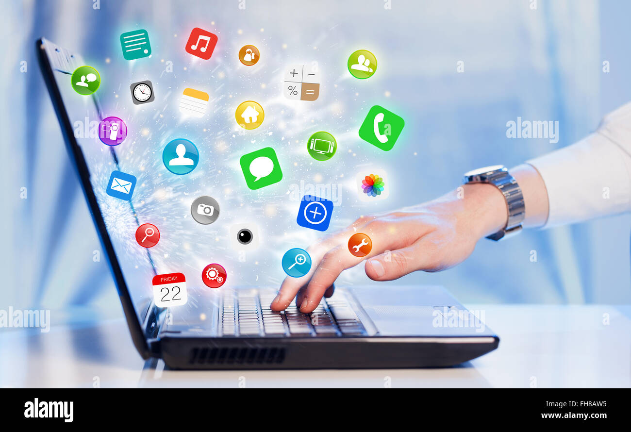 Hand pressing modern laptop with mobile app icons and symbols Stock ...
