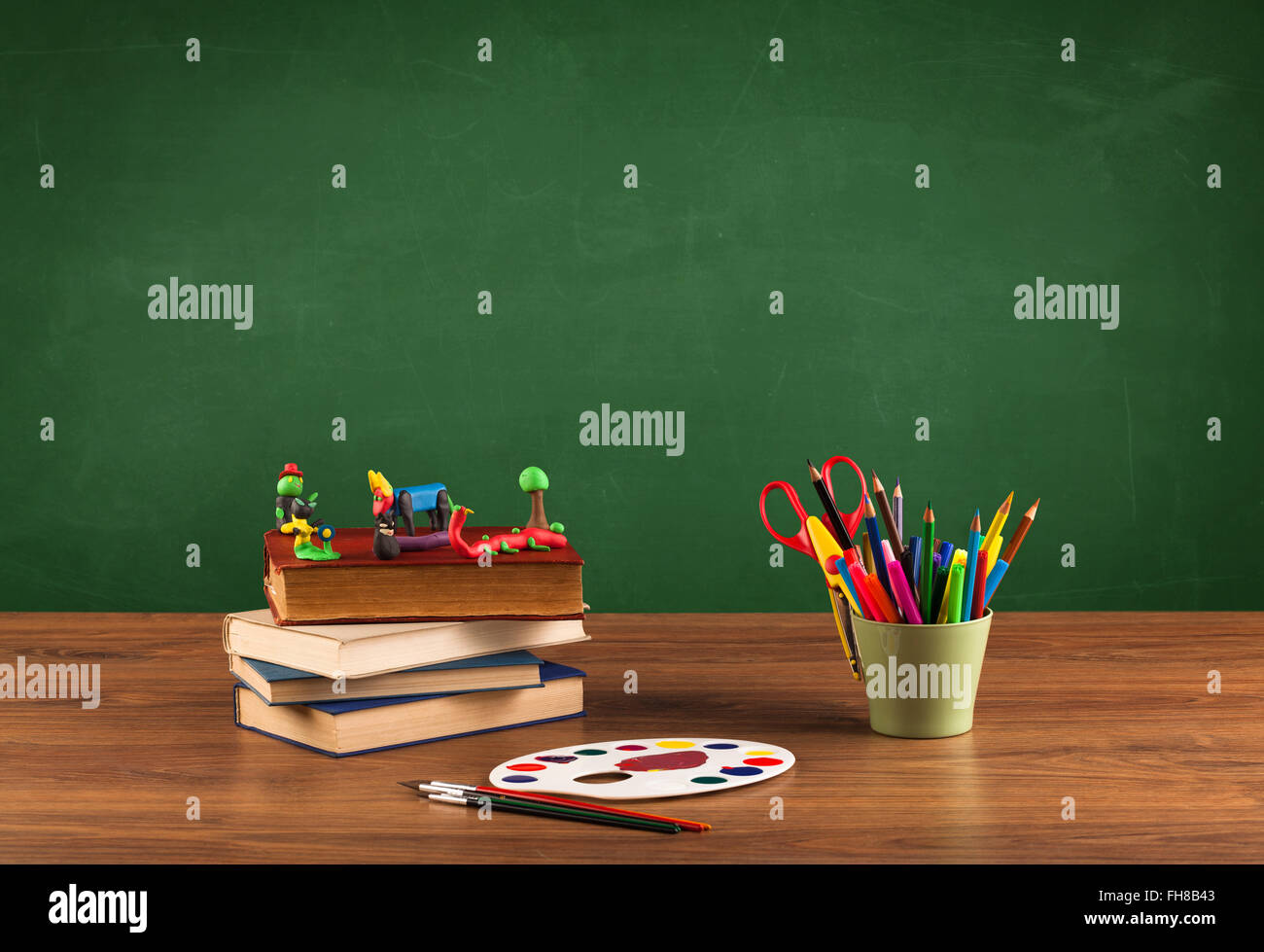 School items on desk with empty chalkboard Stock Photo - Alamy