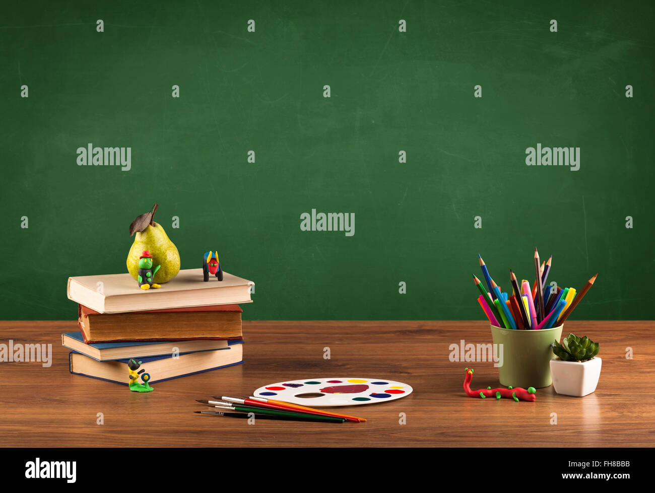 School items on desk with empty chalkboard Stock Photo - Alamy